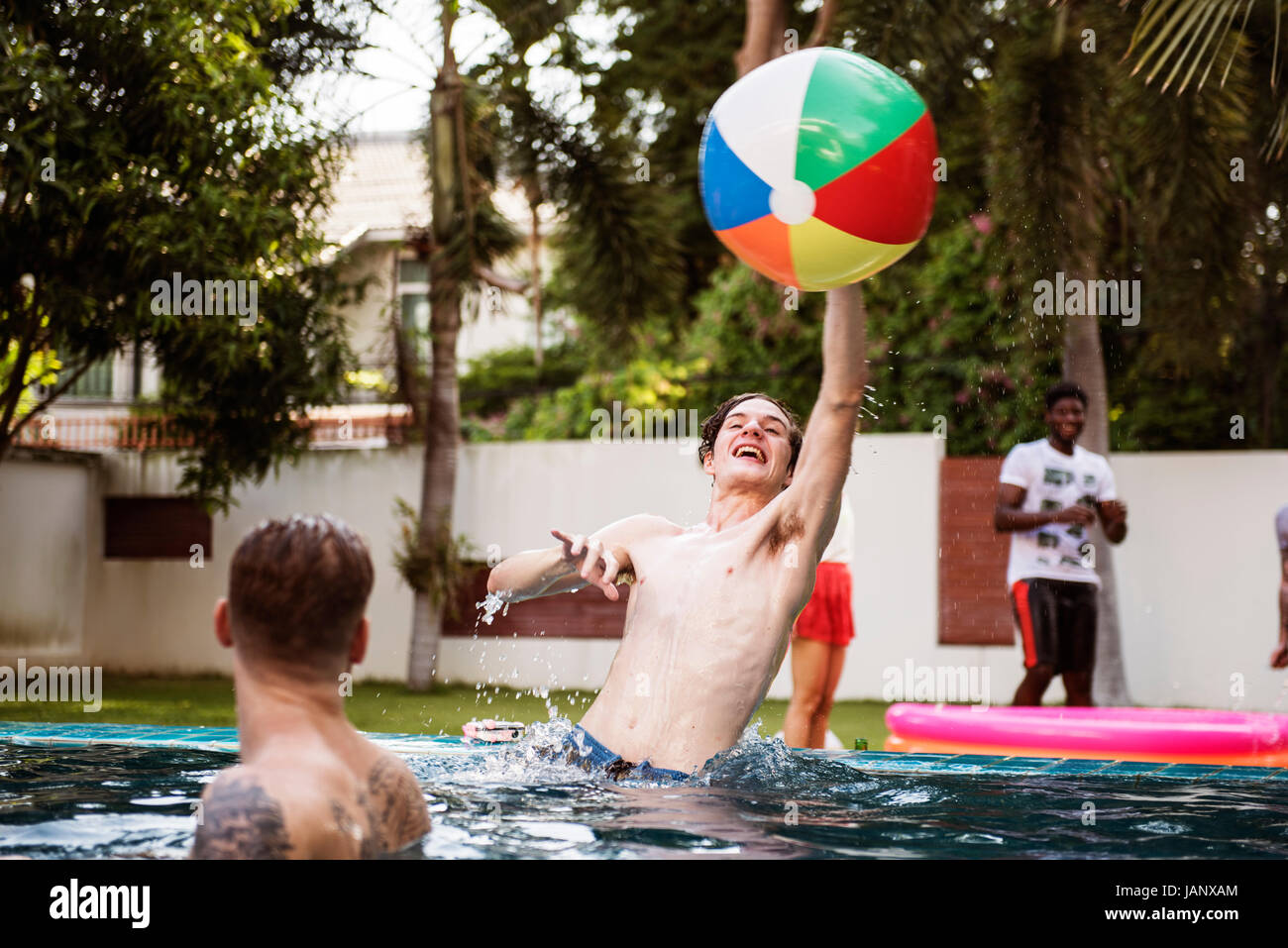 Diverse men playing beach inflatable ball in swimming pool Stock Photo ...
