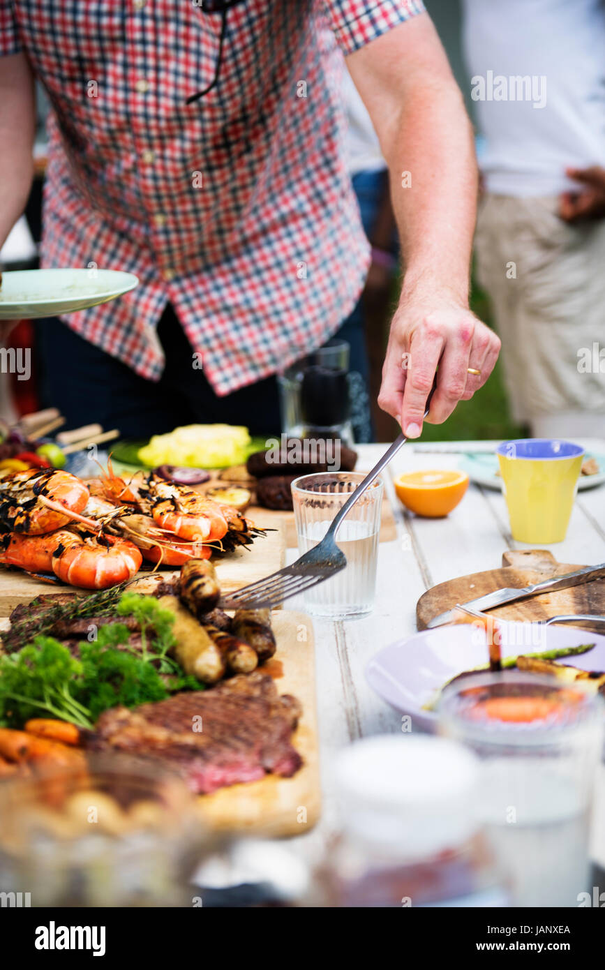 Closeup of man getting food from table Stock Photo - Alamy