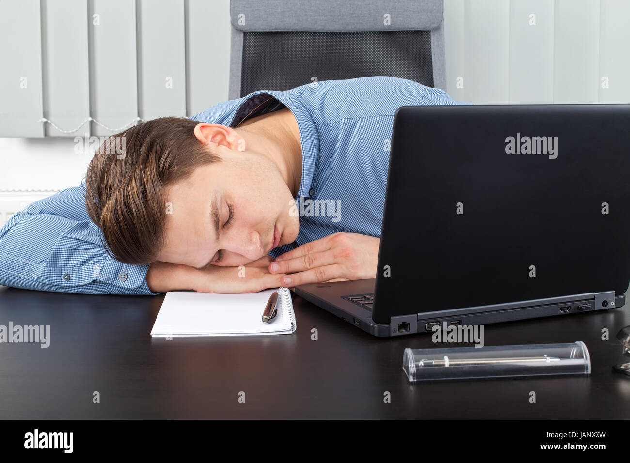 Picture of a young businessman sleeping at the office Stock Photo - Alamy
