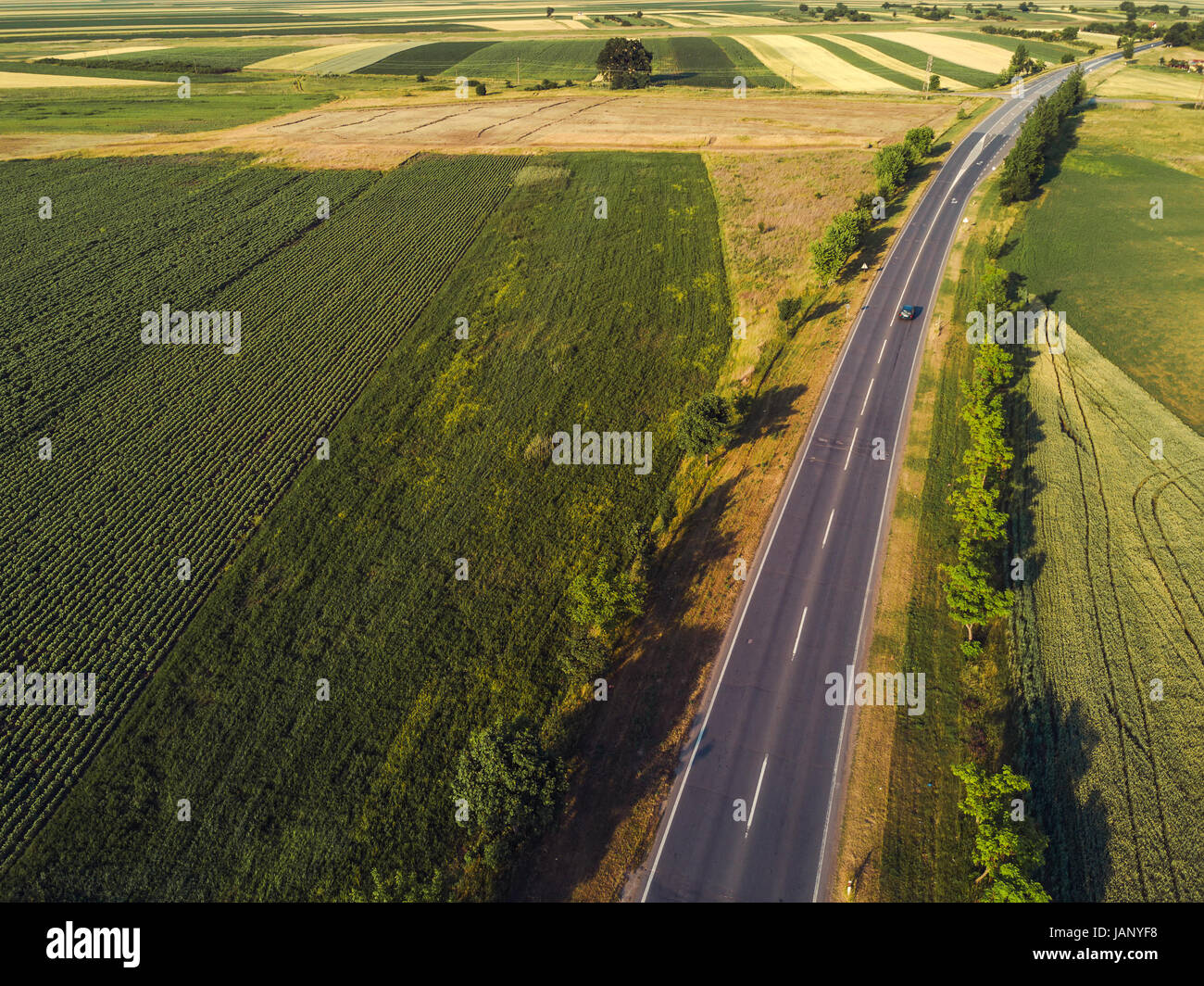Aerial view of traffic on two lane road through countryside and ...
