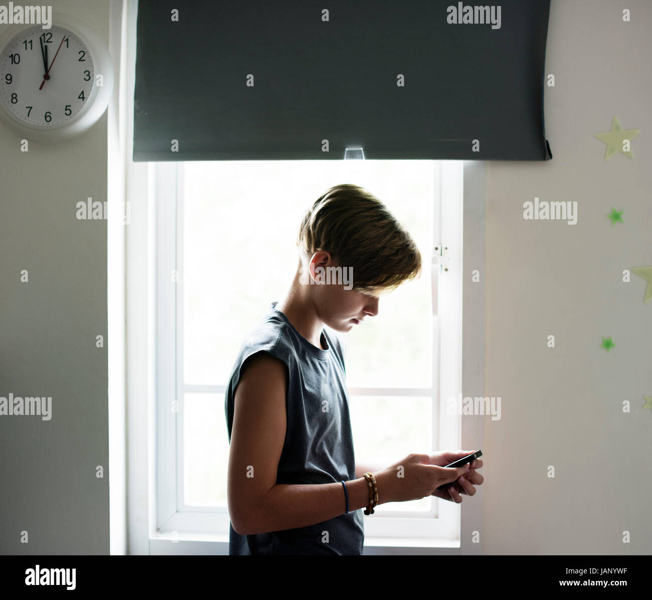 Young caucasian boy using mobile phone in bedroom Stock Photo - Alamy