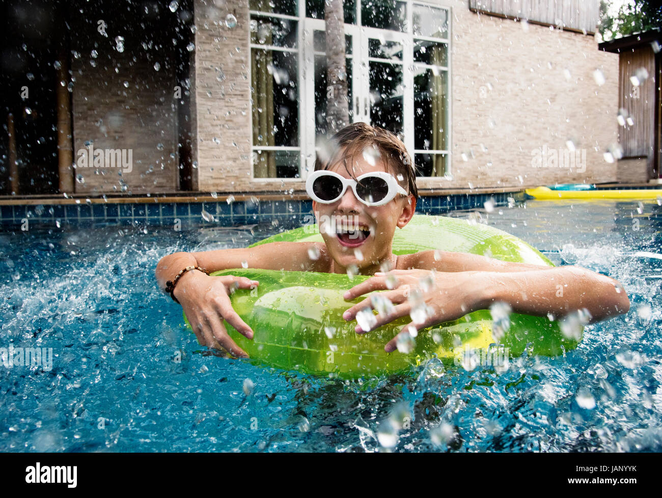 Young caucasian boy enjoying floating in the pool with tube Stock Photo ...