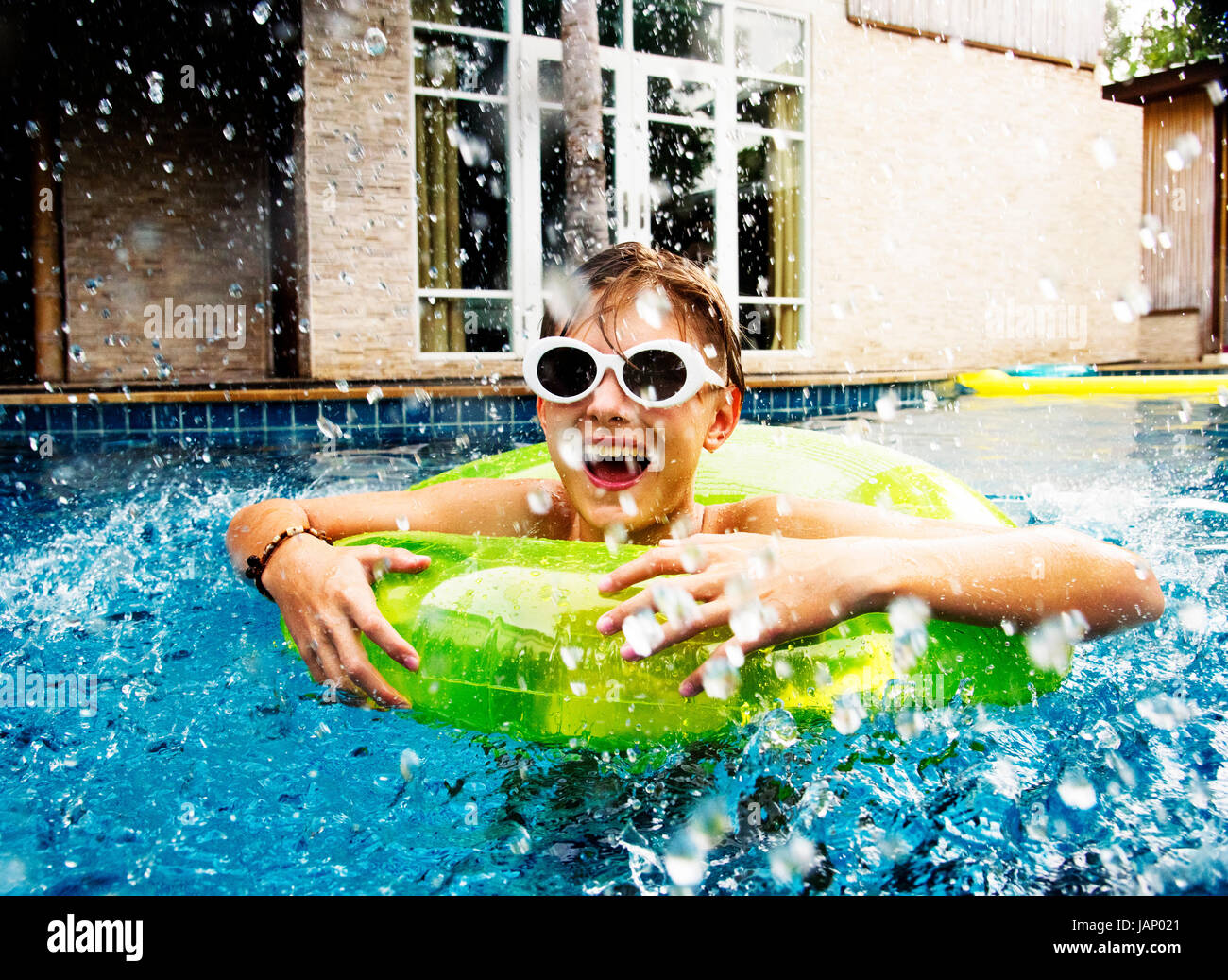 Young caucasian boy enjoying floating in the pool with tube Stock Photo ...