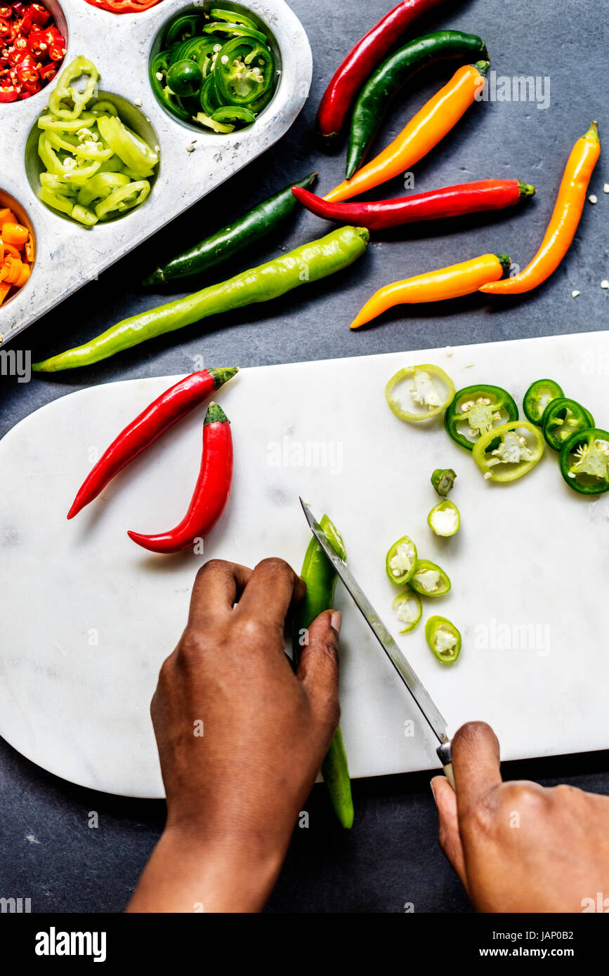 Closeup of hand with knife cutting chili pepper Stock Photo - Alamy