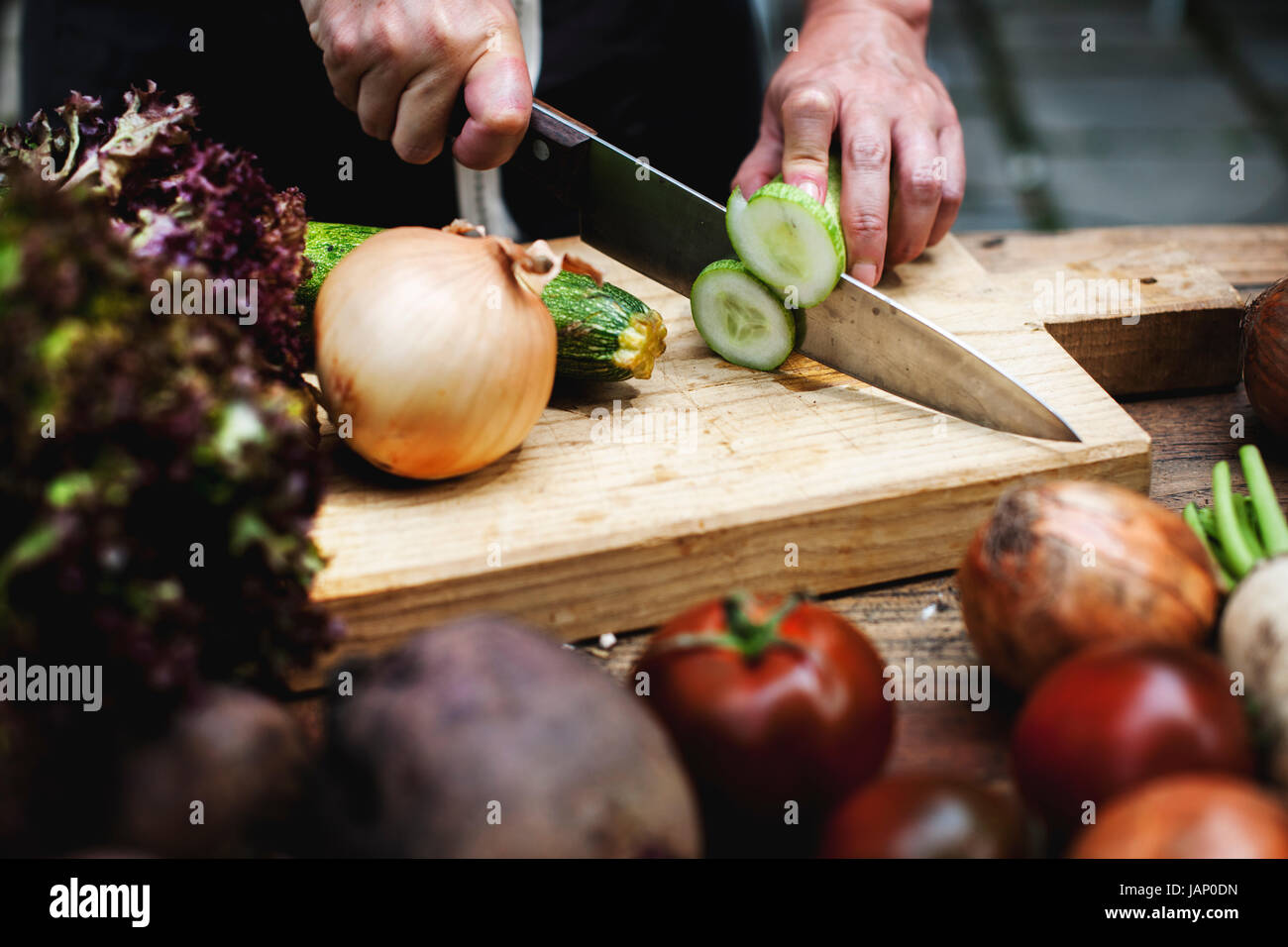 Closeup of hand with knife cutting fresh cucumber Stock Photo - Alamy