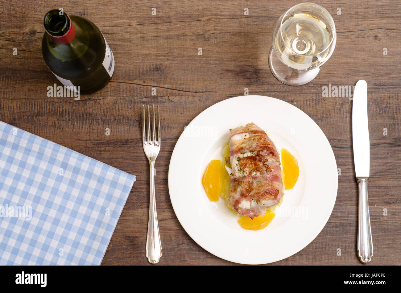 Gebratener Fisch mit Speck mit Weisswein auf einem weissen Teller Stock ...