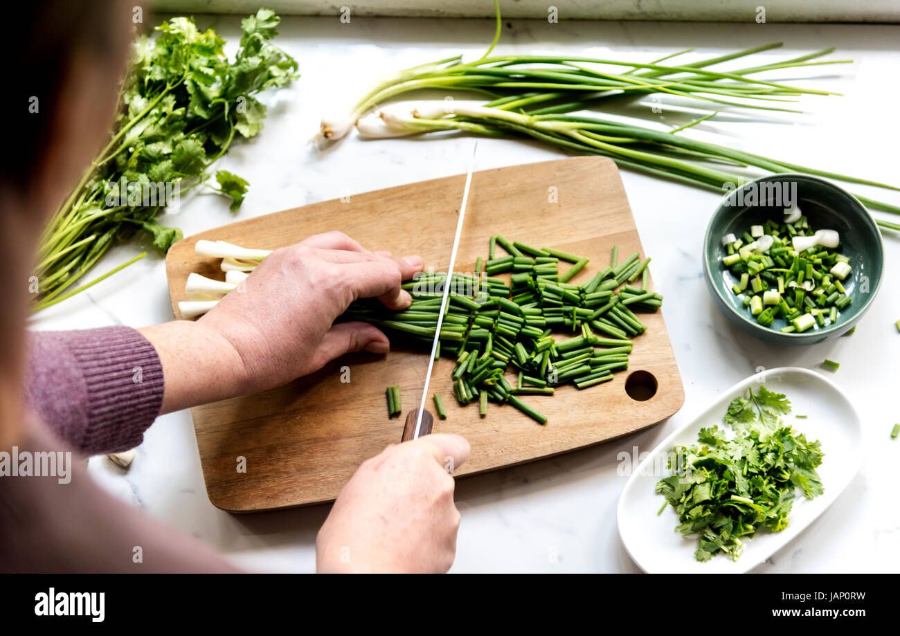 Closeup of hands with knife cutting fresh organic vegetable Stock Photo ...