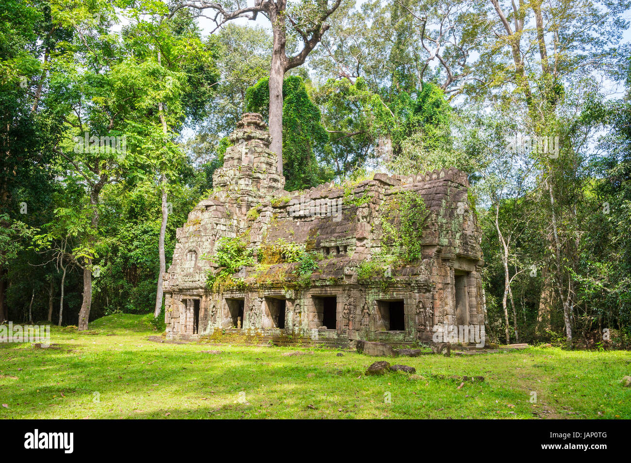 Crumbling temple architecture overtaken by lush green jungle at the ...