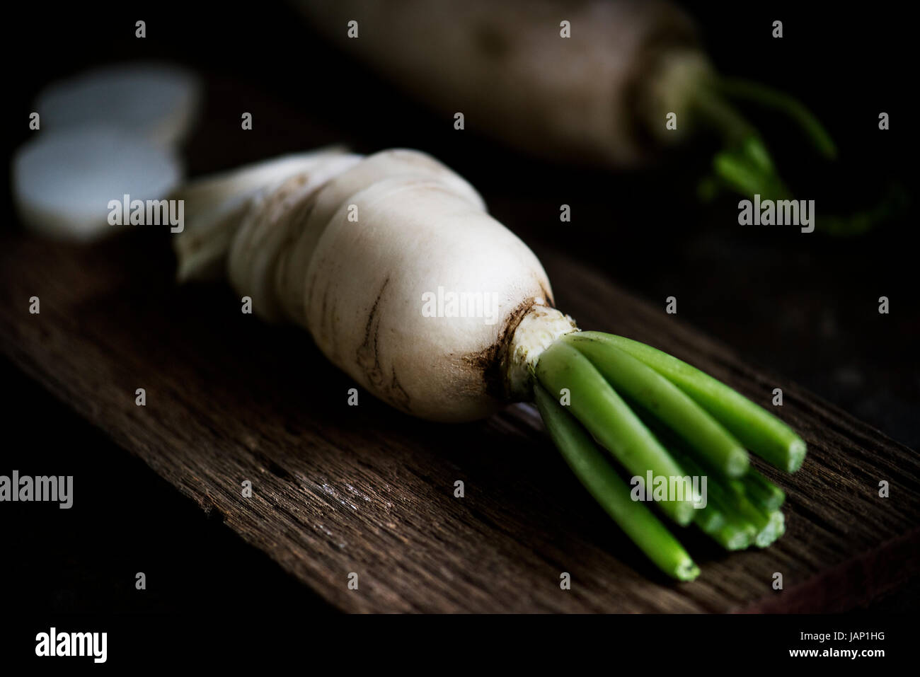 Closeup of cut daikon radish on wooden cutboard Stock Photo - Alamy