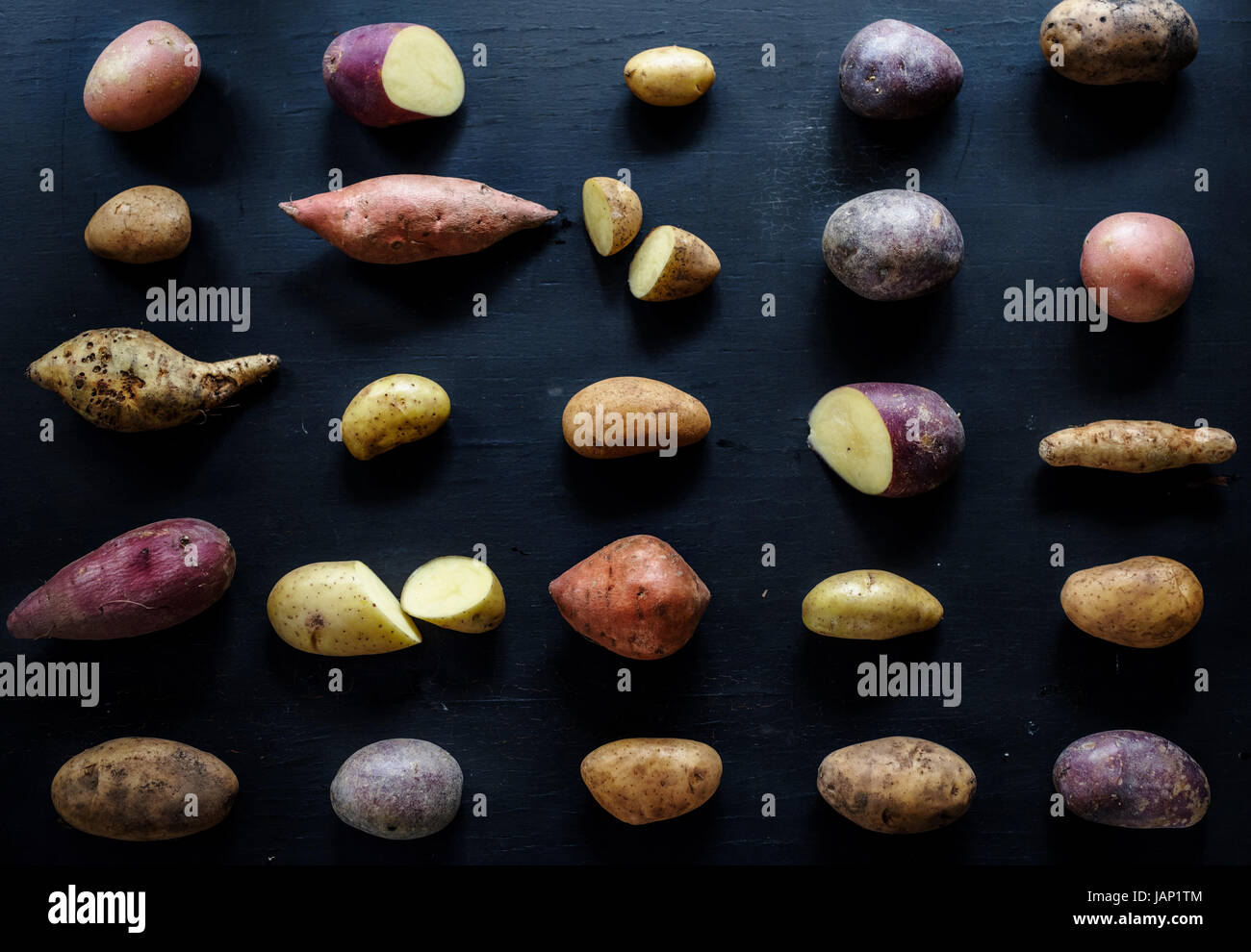 Closeup of fresh various organic potatoes on black background Stock ...