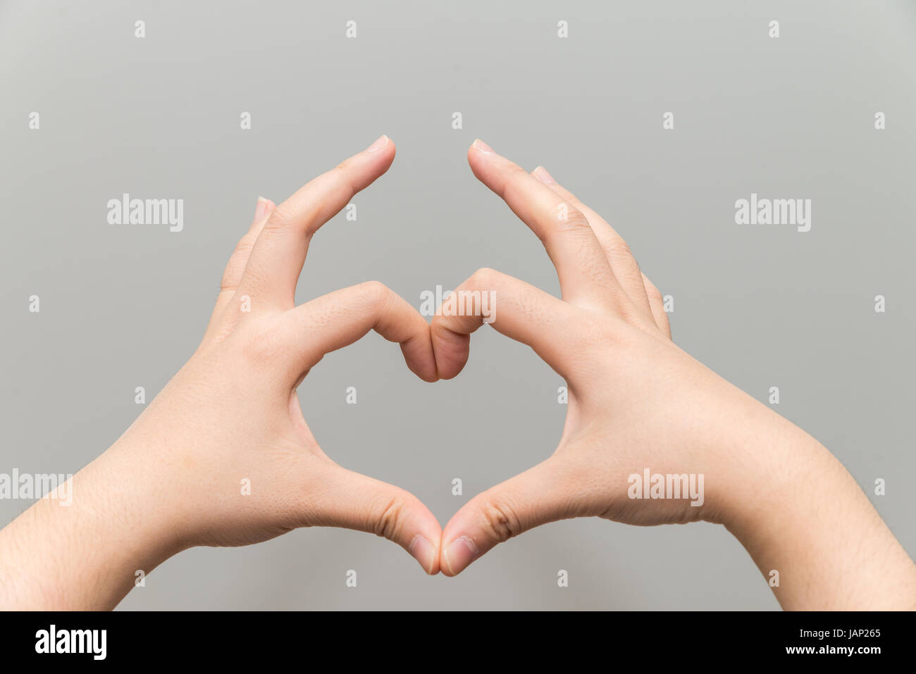Human hands making a heart shape on light gray background Stock Photo ...