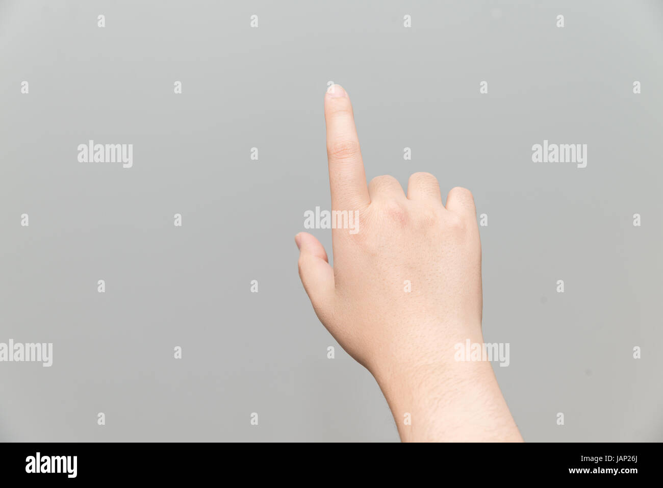 Human hand with one finger touching imaginary tablet on gray background ...