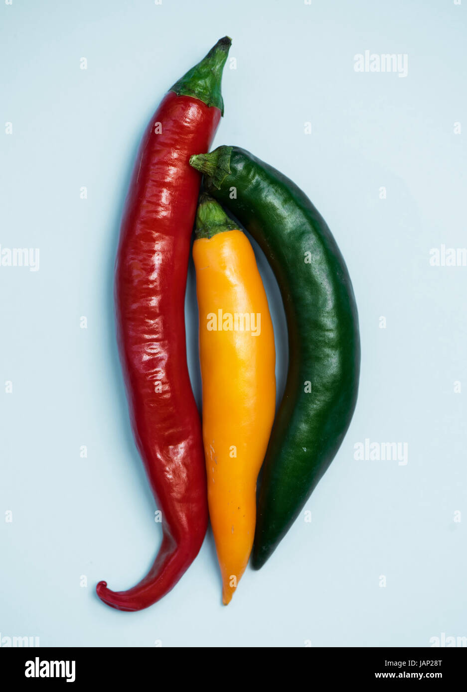 Aerial view of fresh red green yellow chili peppers on white background ...