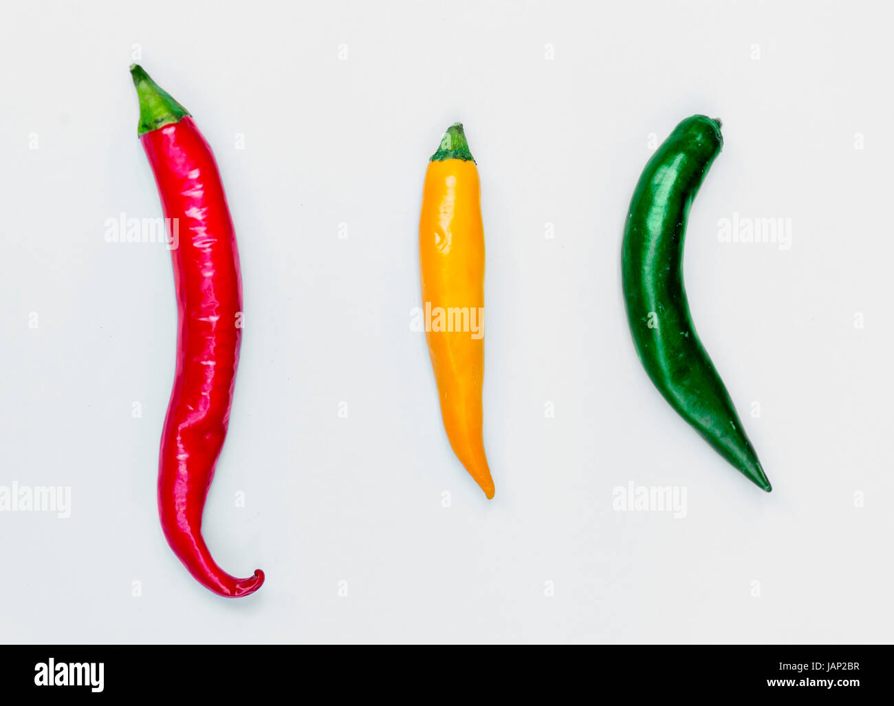 Aerial view of fresh red green yellow chili peppers on white background ...