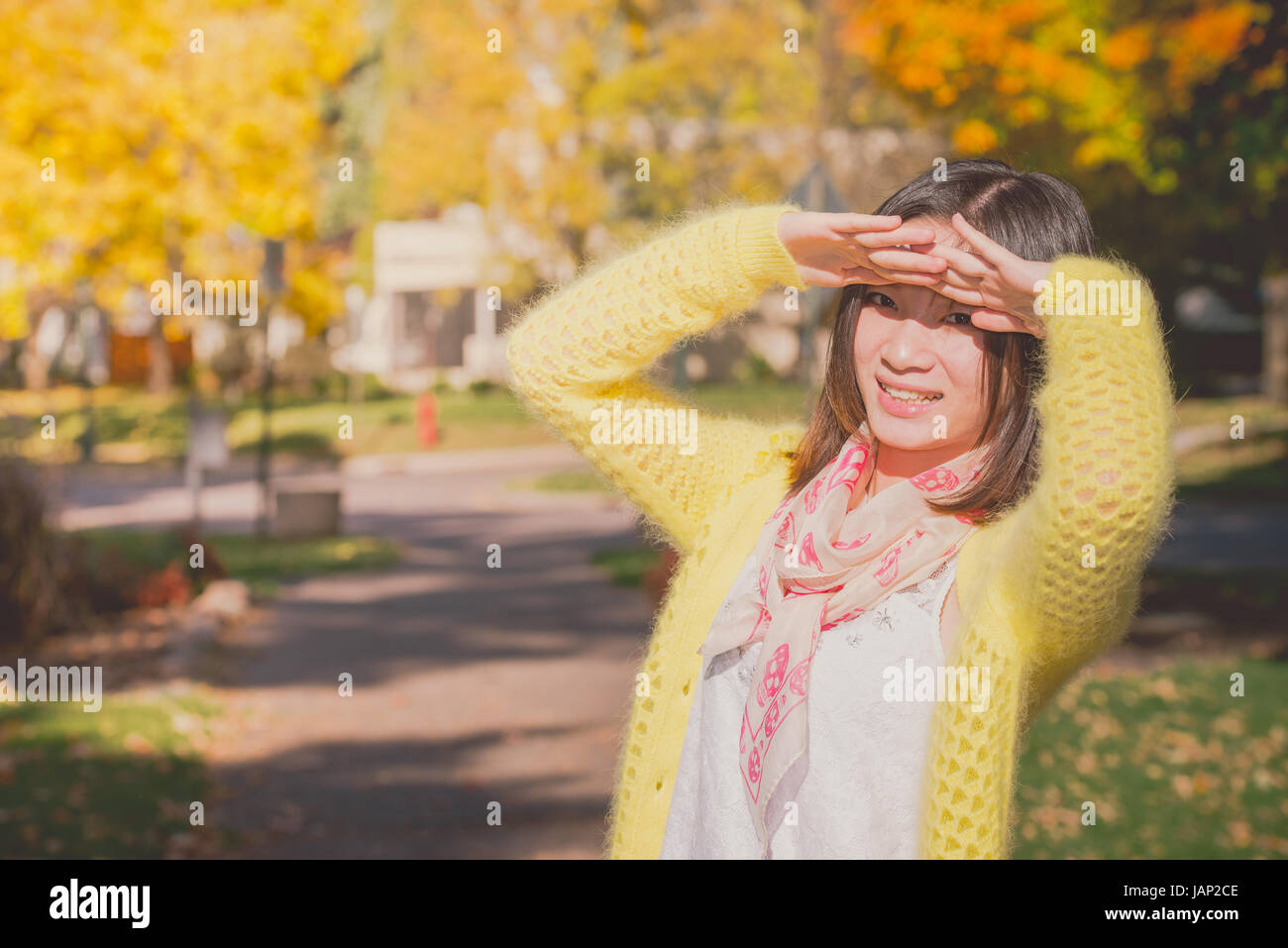 Young woman shielding herself from the bright sun with one hand Stock ...