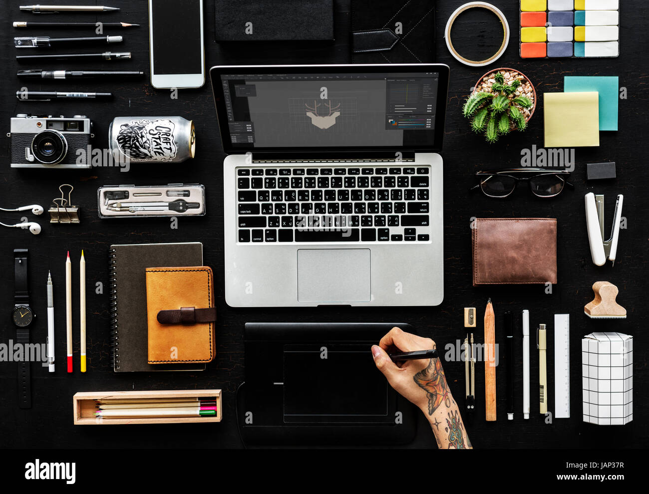 Aerial view of tattooed hands using pen mouse drawing graphic design ...