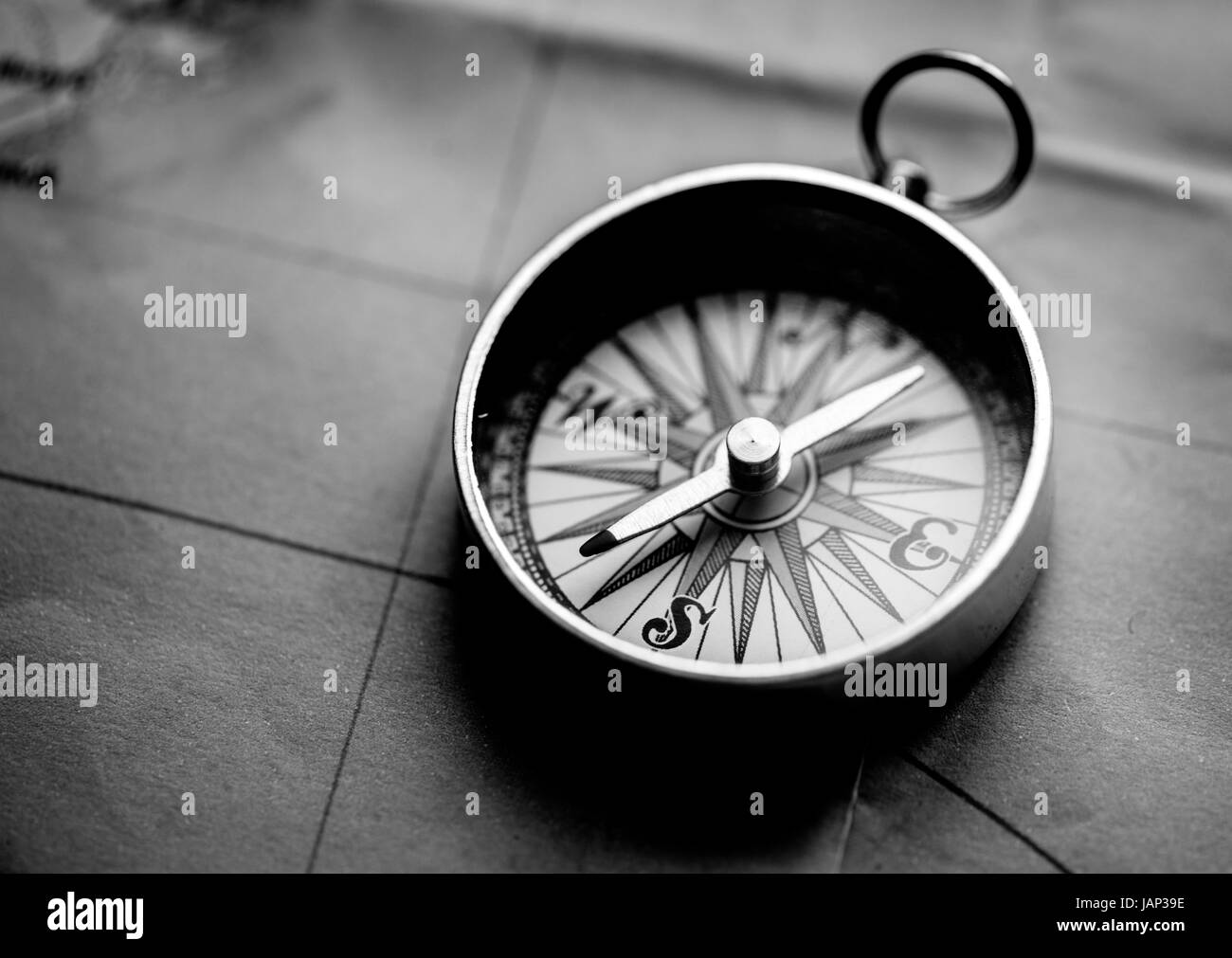 Closeup of metallic compass on the map journey planning grayscale Stock ...