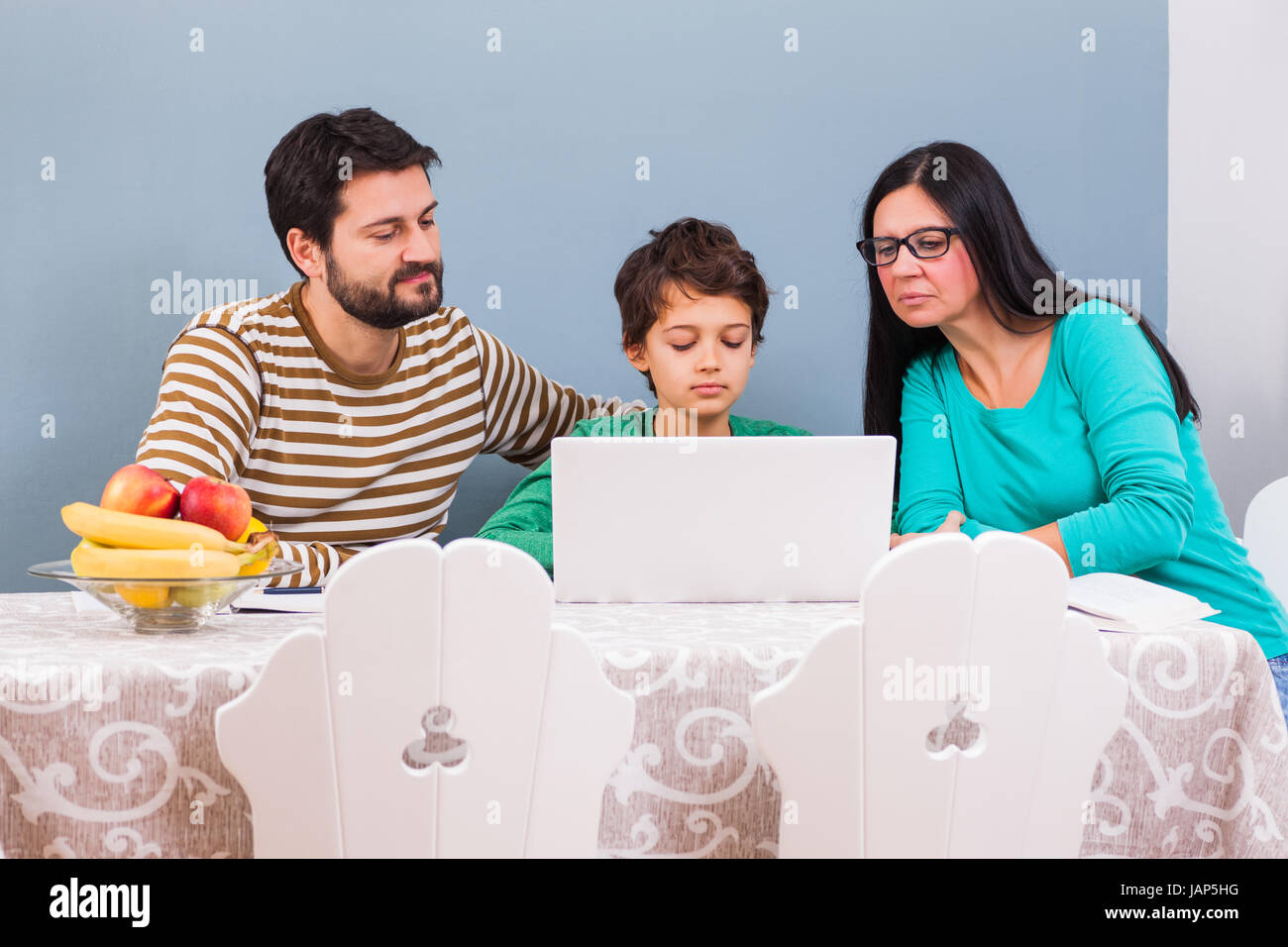 Parents are teaching their son to use laptop Stock Photo - Alamy