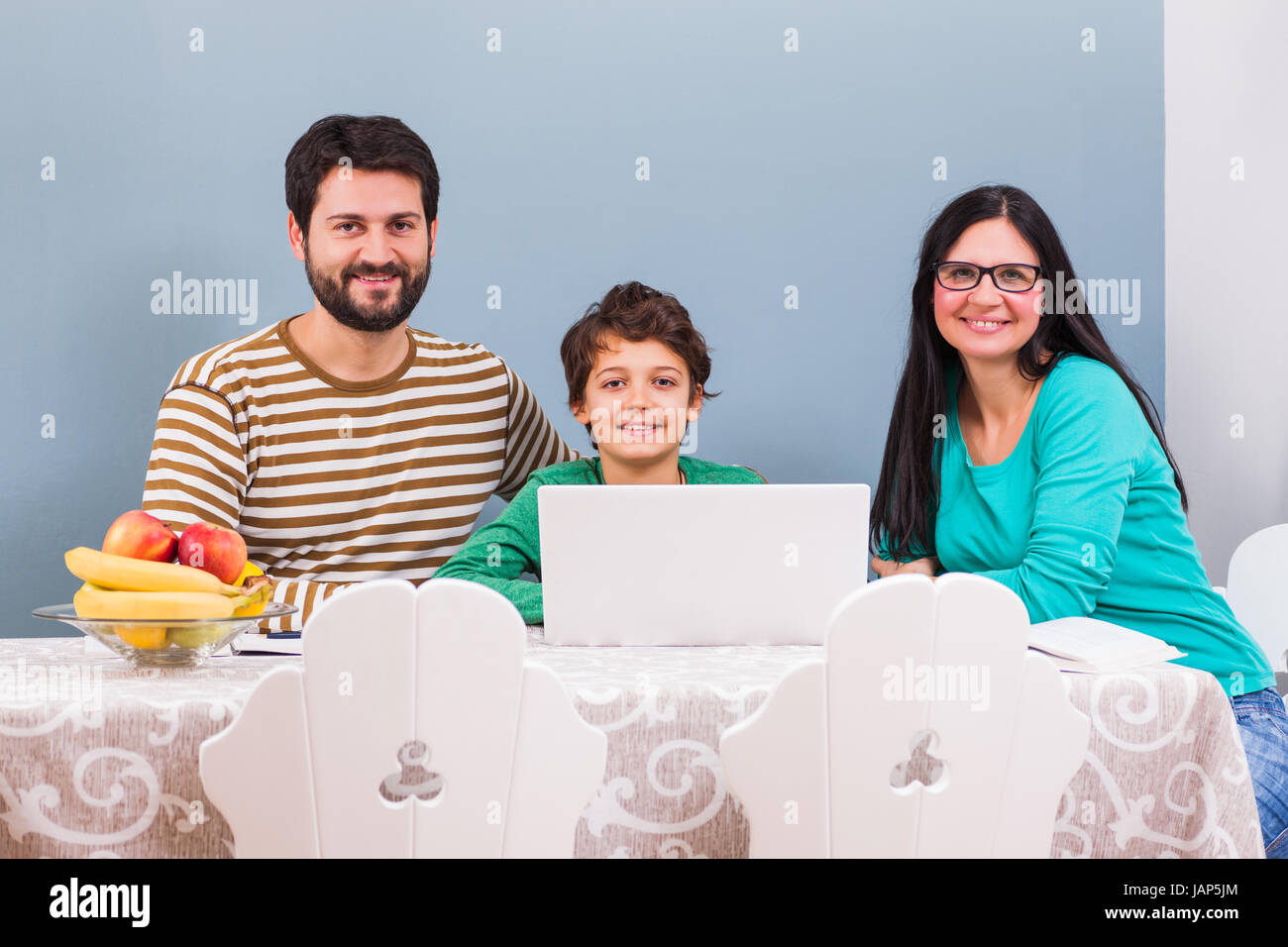 Parents are teaching their son to use laptop Stock Photo - Alamy