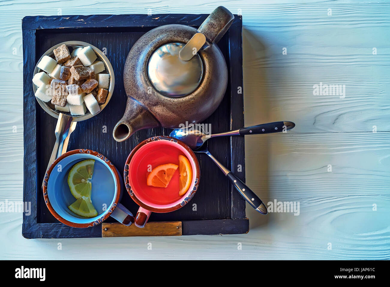 Tea set with cups, teapot, spoons and sugar on white wooden table Stock ...