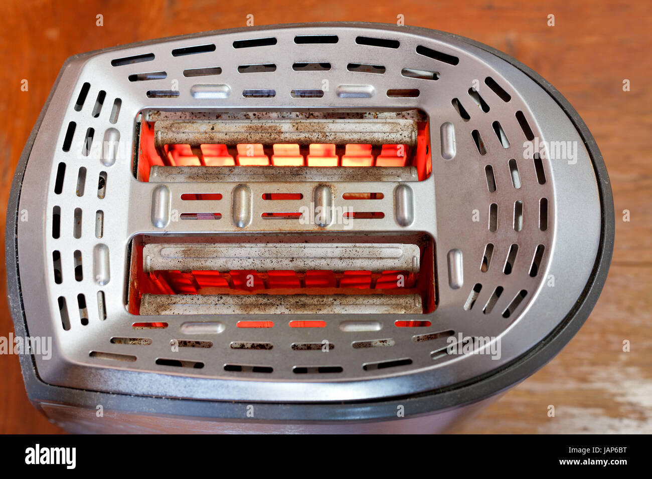 two slices of bread toasting in metal toaster on wooden table Stock ...