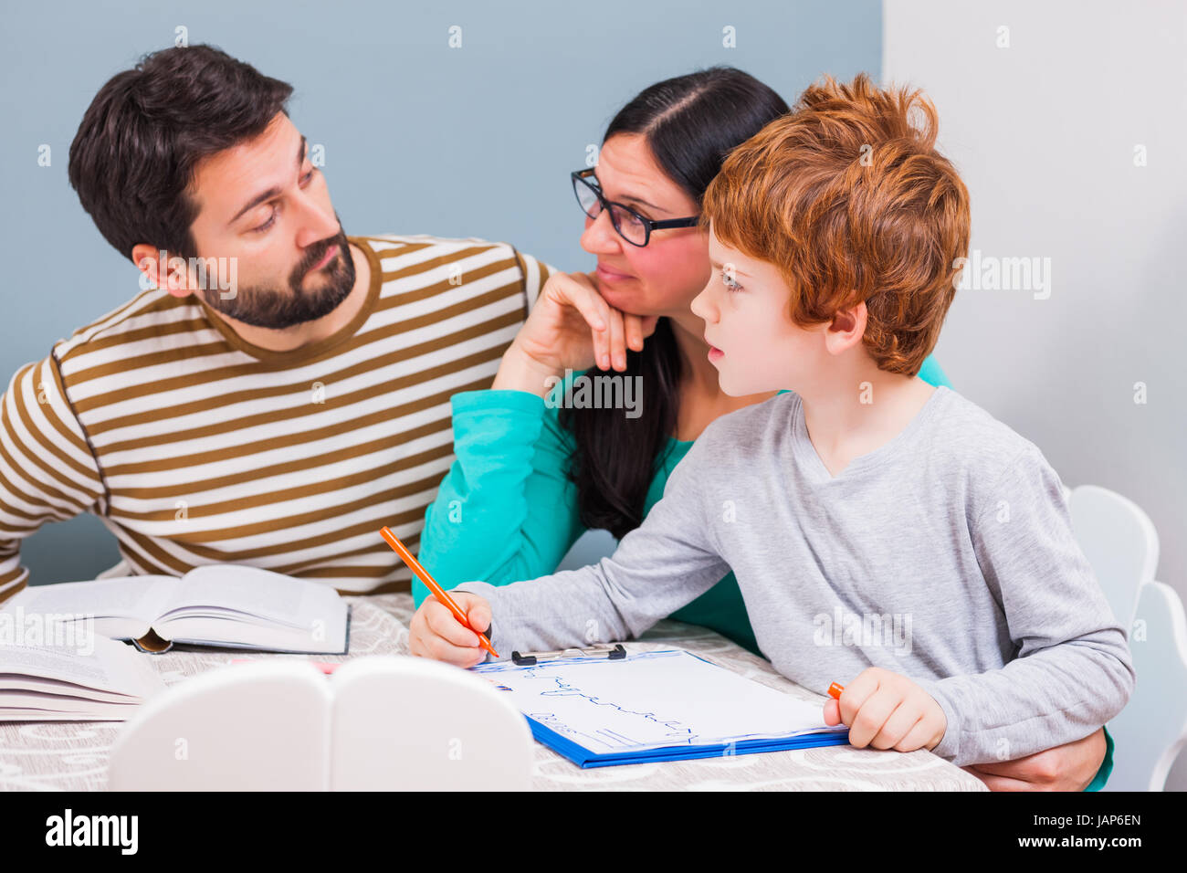 Parents are teaching their son at home Stock Photo - Alamy