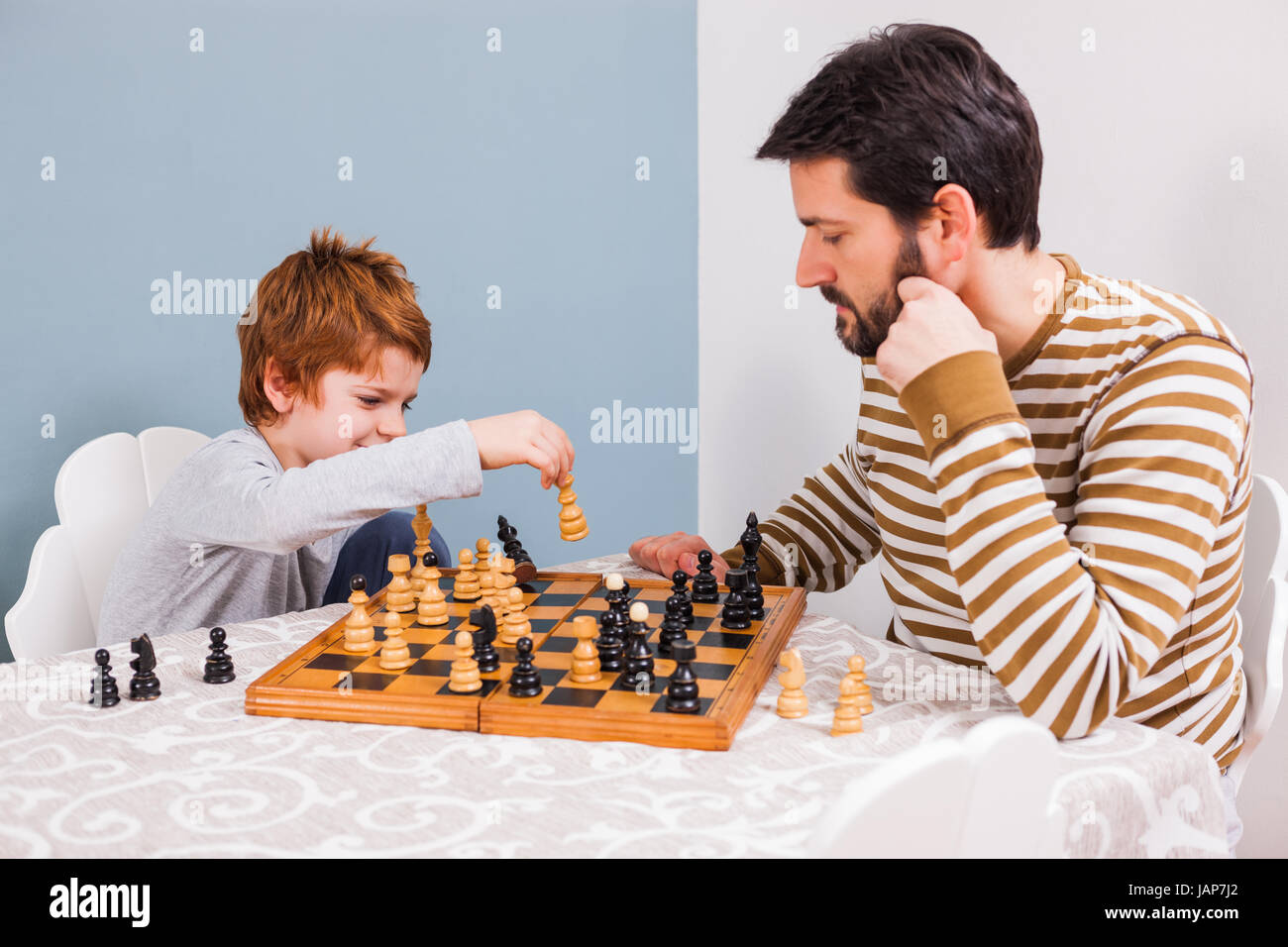 Father and son are playing chess at home Stock Photo - Alamy