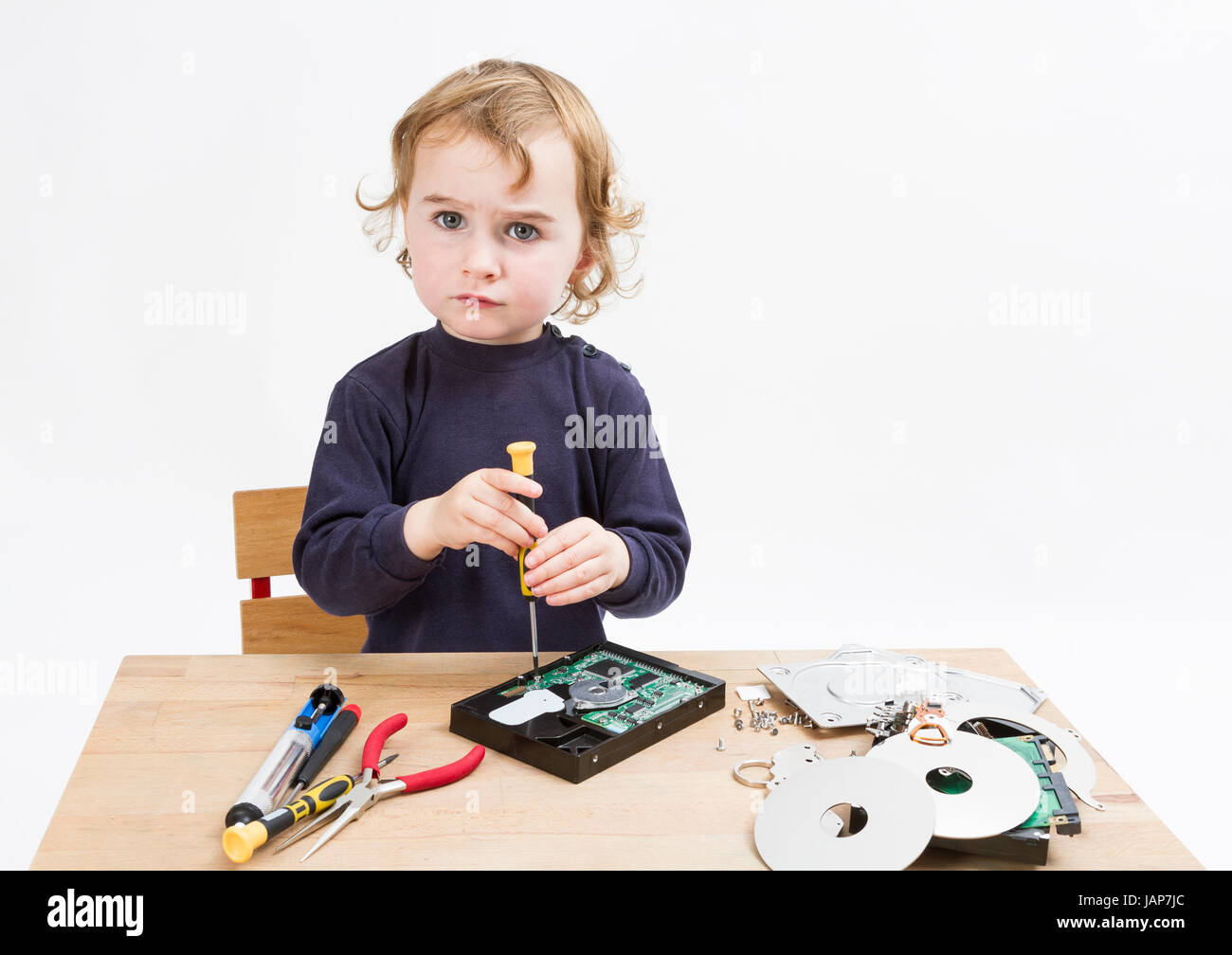 child repairing computer part. studio shot in light grey background ...
