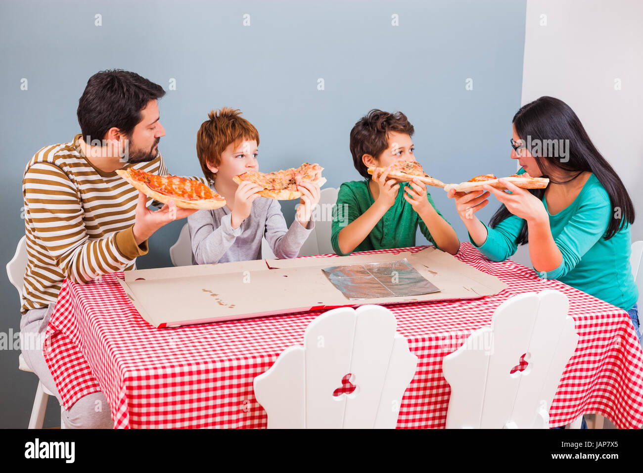 Parents and their two sons are eating pizza at home Stock Photo - Alamy
