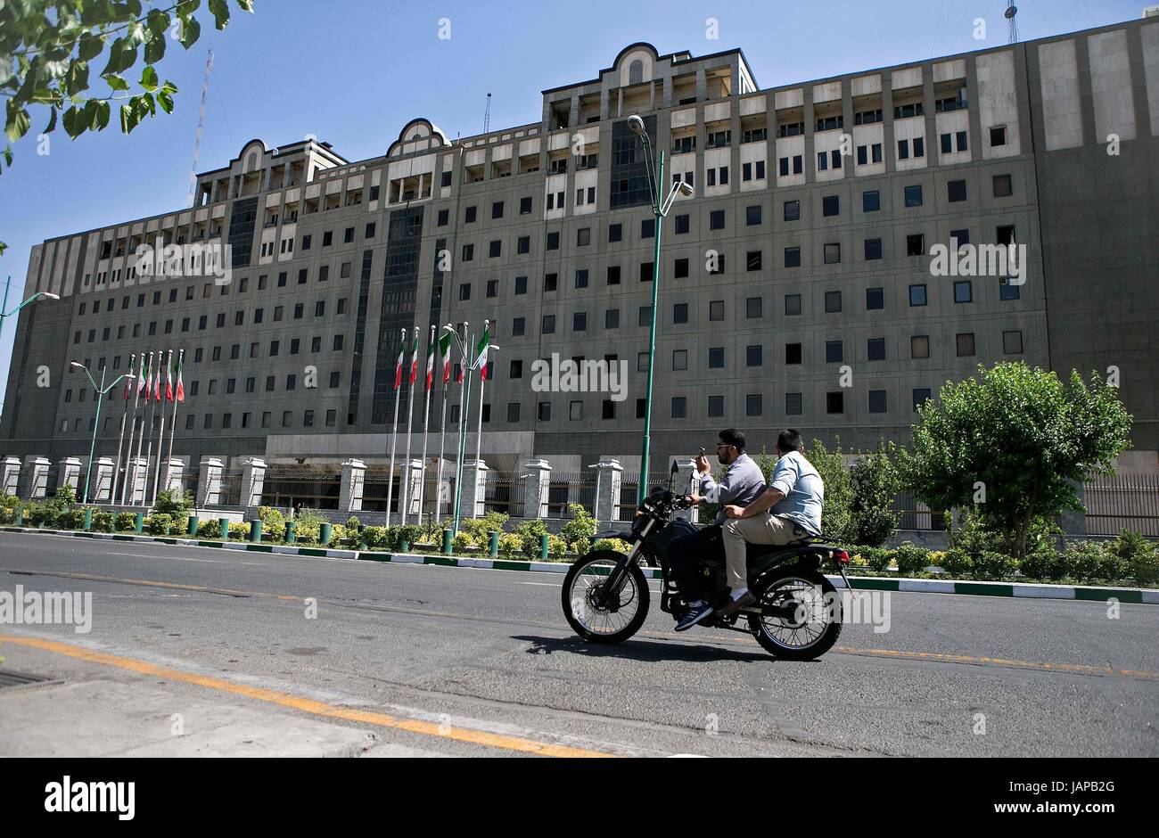 Tehran, Iran. 7th June, 2017. People ride past Iran's parliament in ...