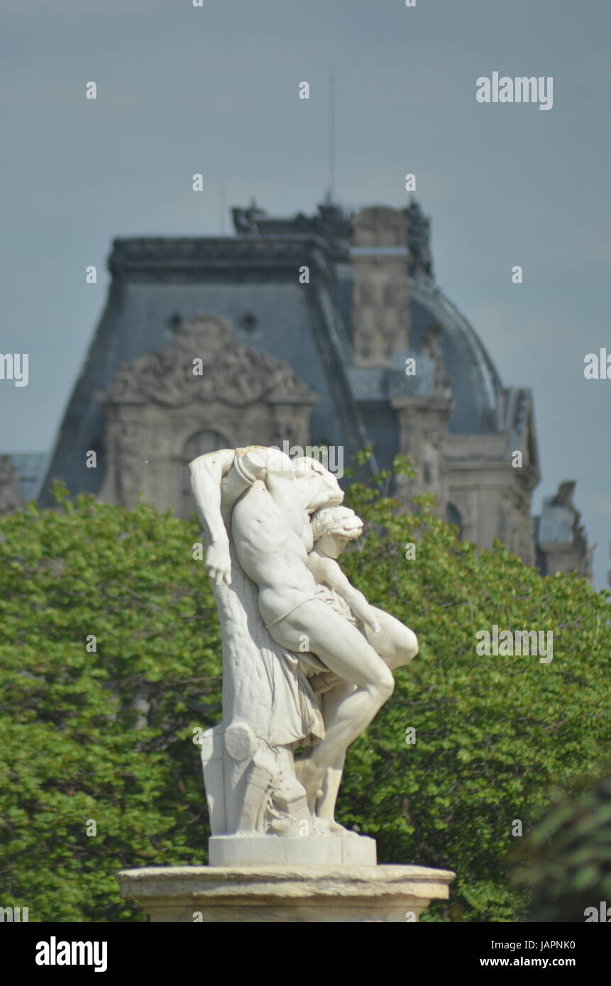 A white marble statue against trees and the backdrop of a typical Paris ...