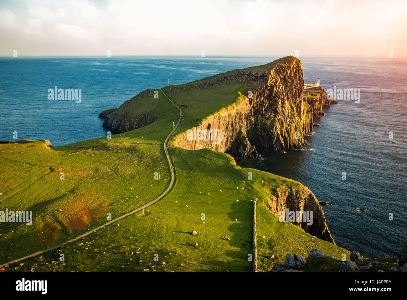 Neist point Lighthouse in light of setting sun. Landscape of Scotland ...