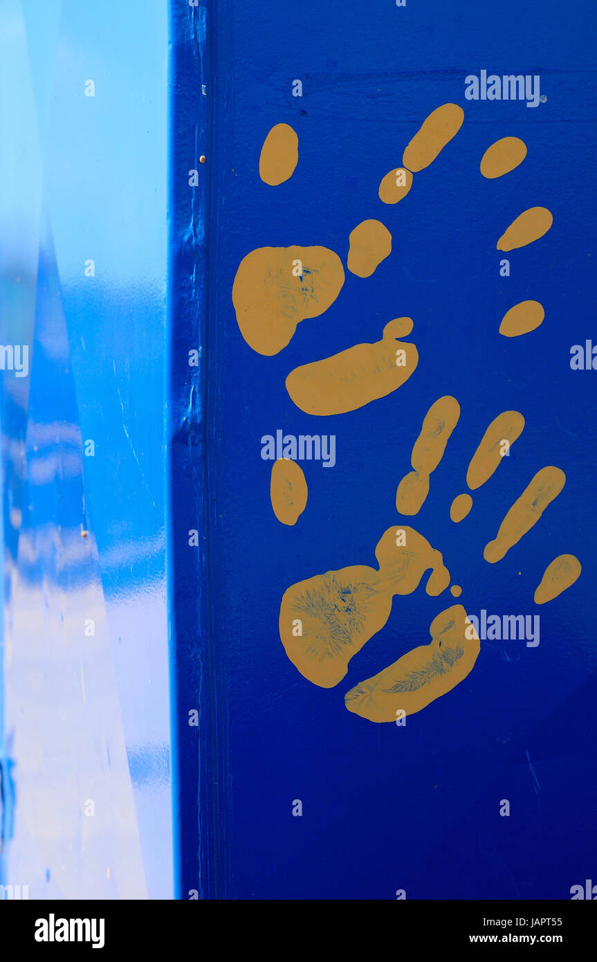 orange painted hands on blue support Stock Photo - Alamy