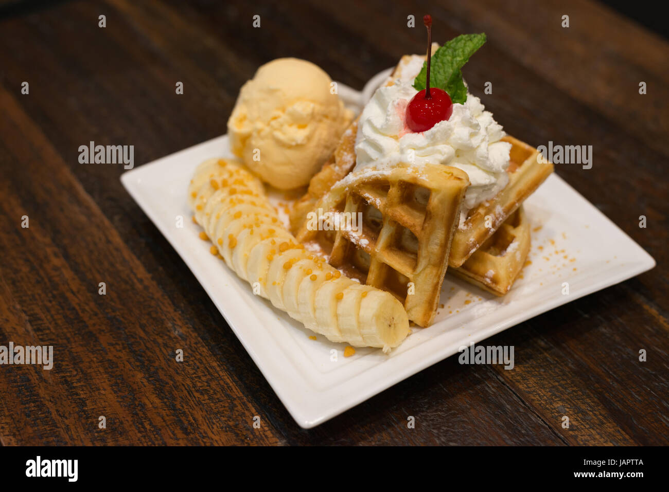 Waffle topped with ice cream , banana and wipe cream Stock Photo - Alamy