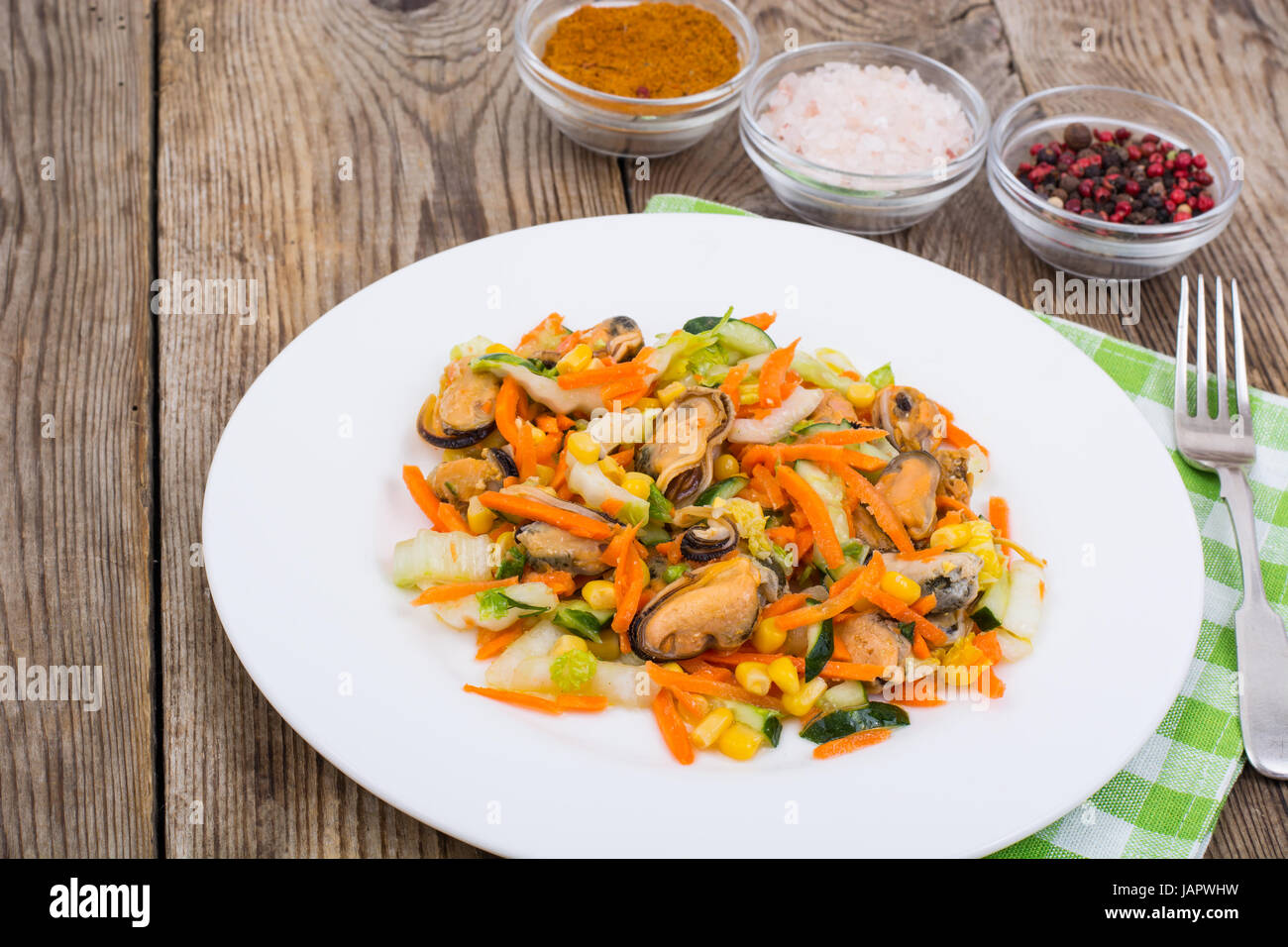 Peking cabbage, corn, cucumber, mussels on a white saucer on an Stock ...