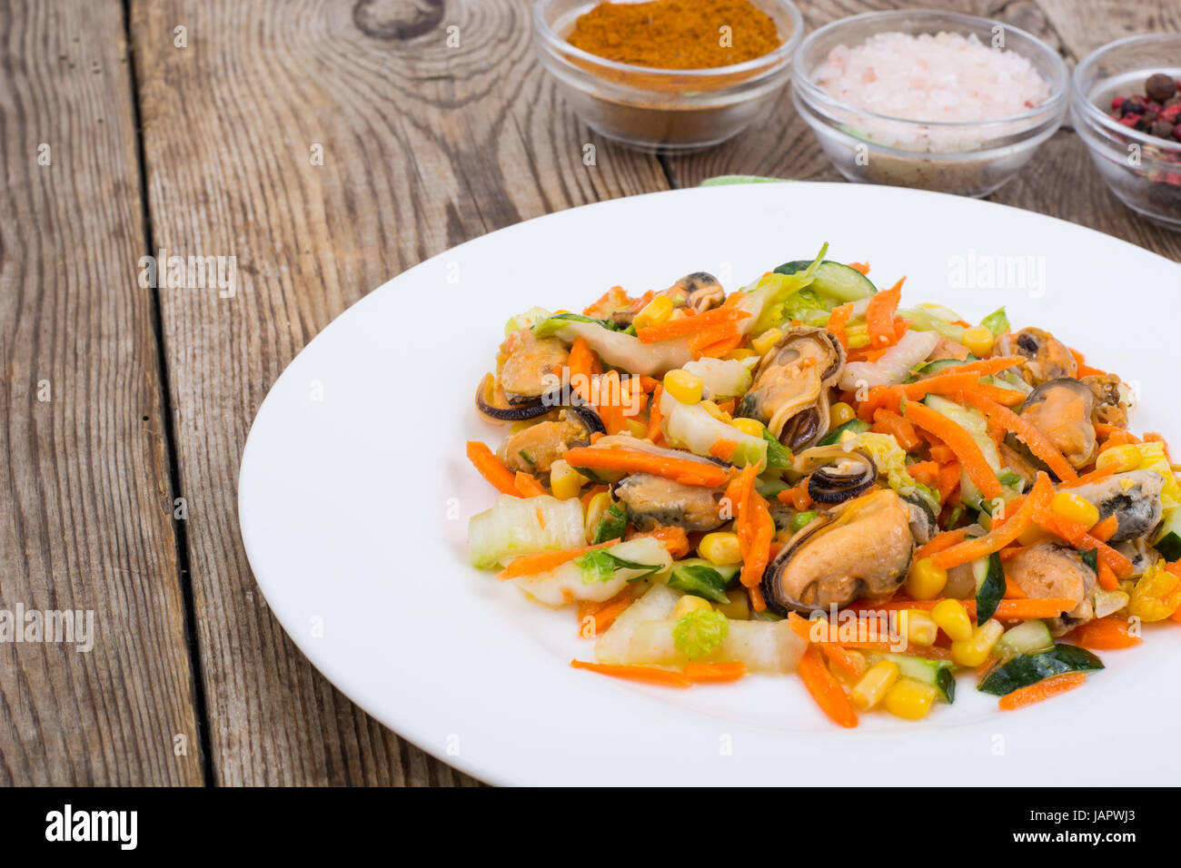 Peking cabbage, corn, cucumber, mussels on a white saucer on an Stock ...