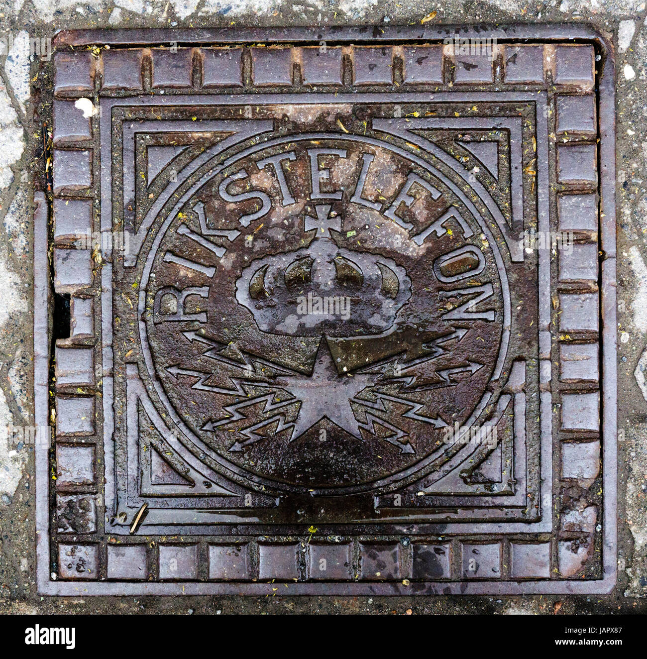Historic metal manhole cover marked “Rikstelefon” with crown emblem ...