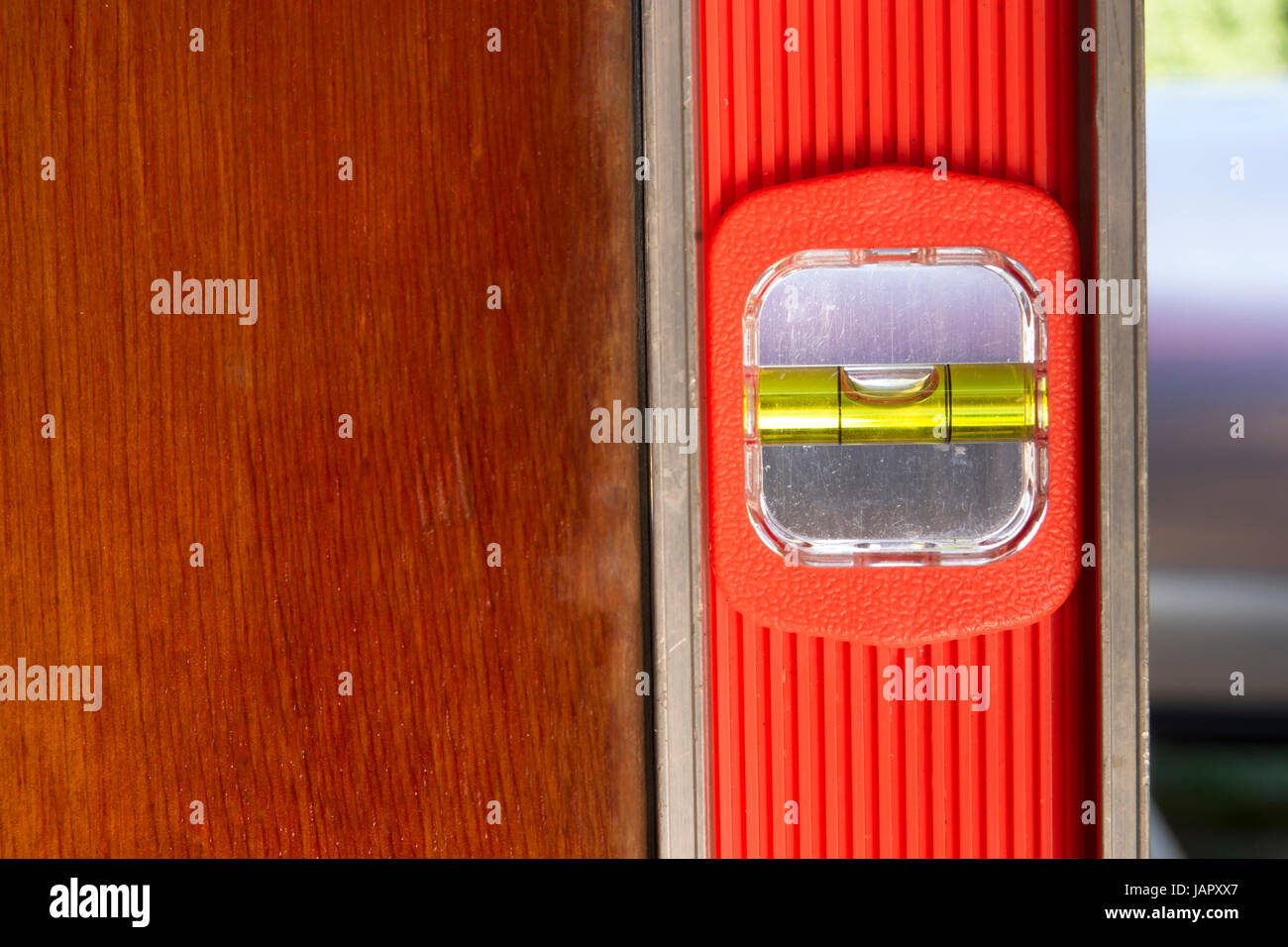 An old orange level stands up against a wood door Stock Photo - Alamy