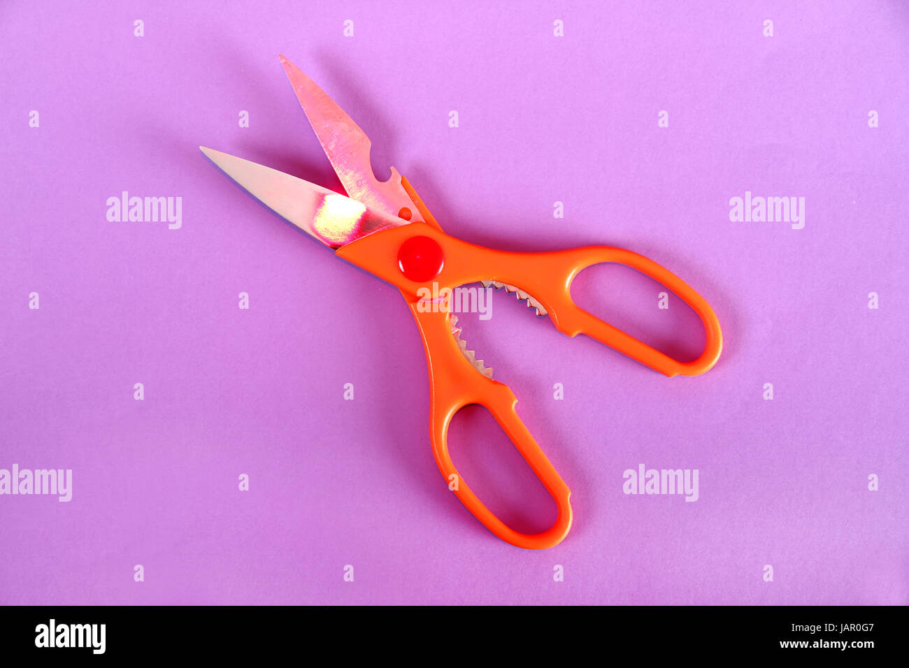 A Scissor on a purple paper background Stock Photo - Alamy