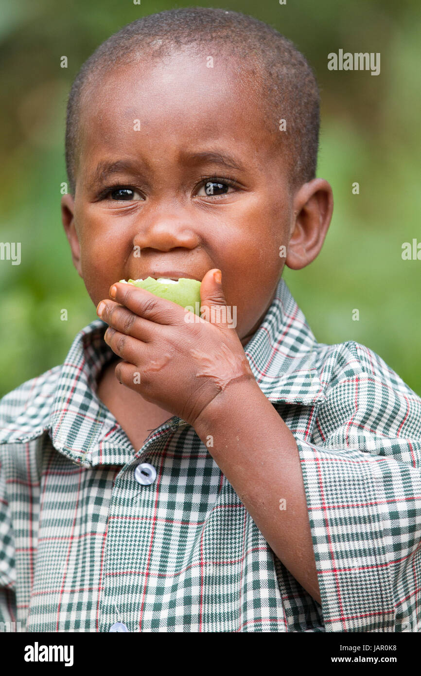 A young child eating an apple, Kenya, Africa Stock Photo - Alamy