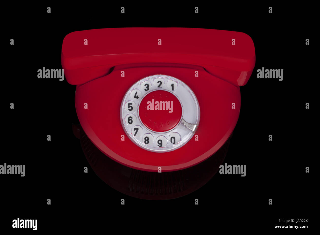 Red round retro phone from the sixties isolated on black background ...