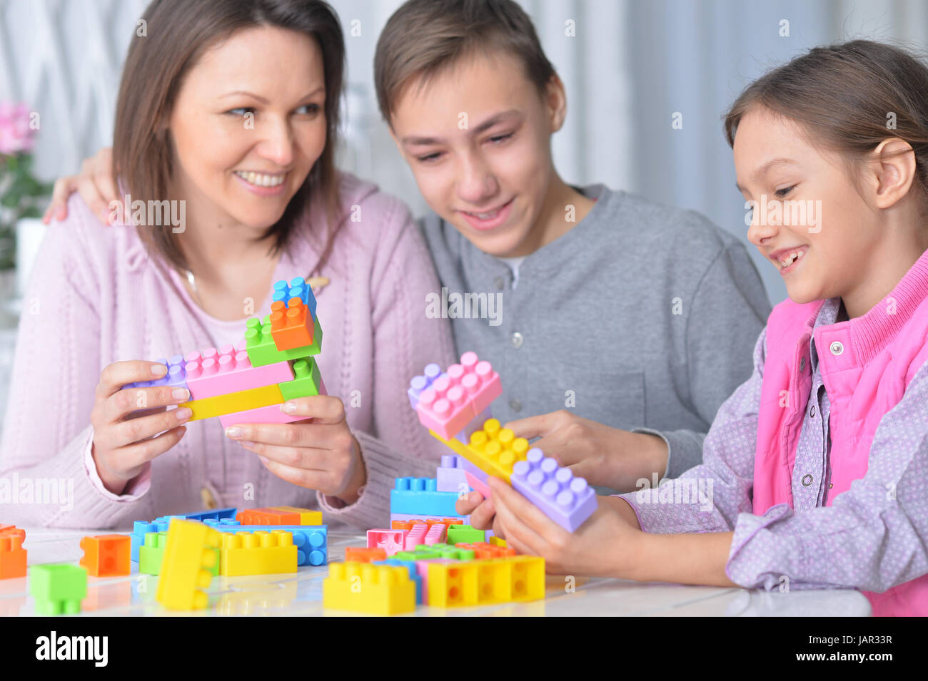 Portrait of a happy family collecting colorful blocks together Stock ...