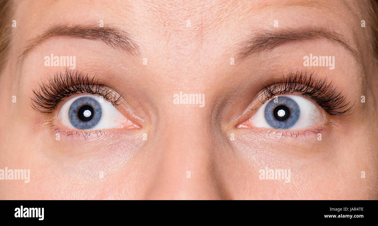 Close-up scared face of beautiful young woman with beautiful blue eyes ...