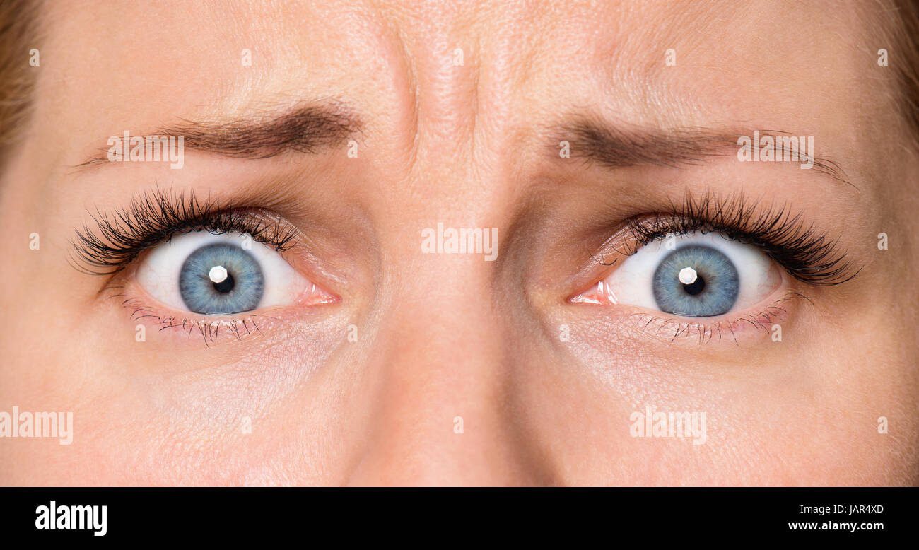 Close-up scared face of beautiful young woman with beautiful blue eyes ...