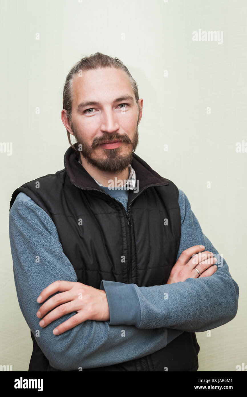 Close-up vertical portrait of smiling young bearded Asian man above ...