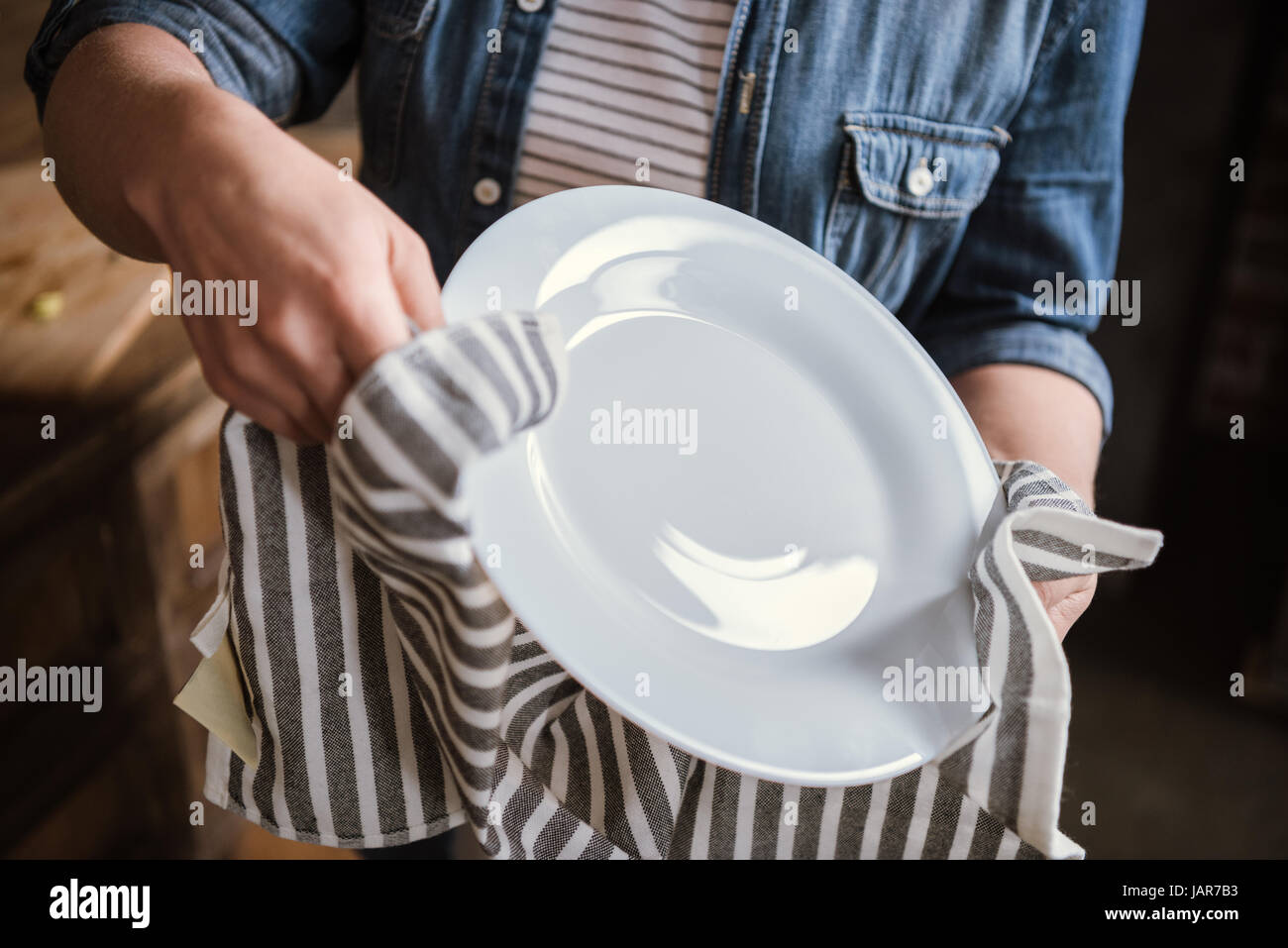 Woman wiping plate Stock Photo - Alamy