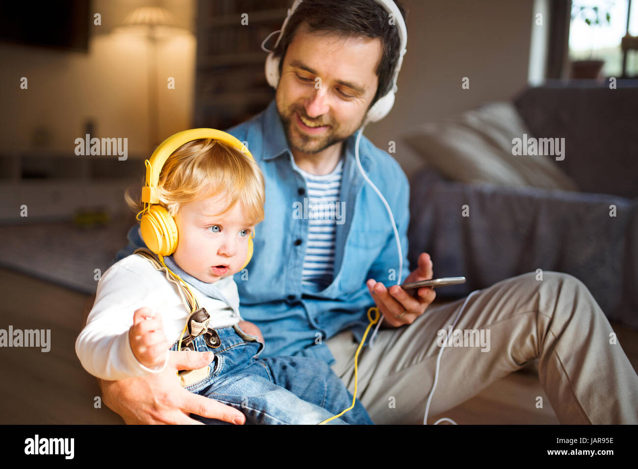 Father and son with smartphone and earphones, listening music Stock ...