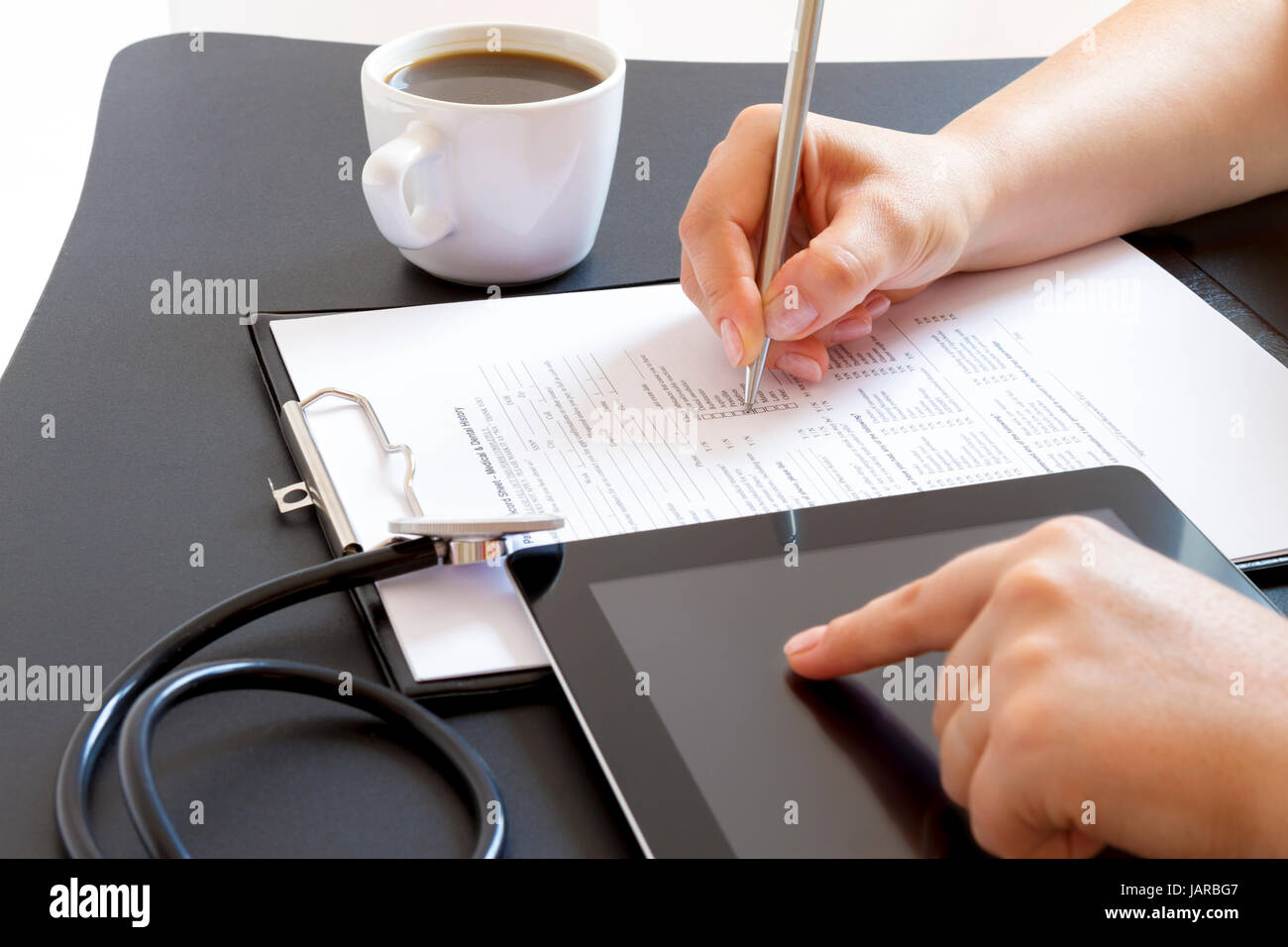 Female doctor using digital tablet, side view Stock Photo - Alamy
