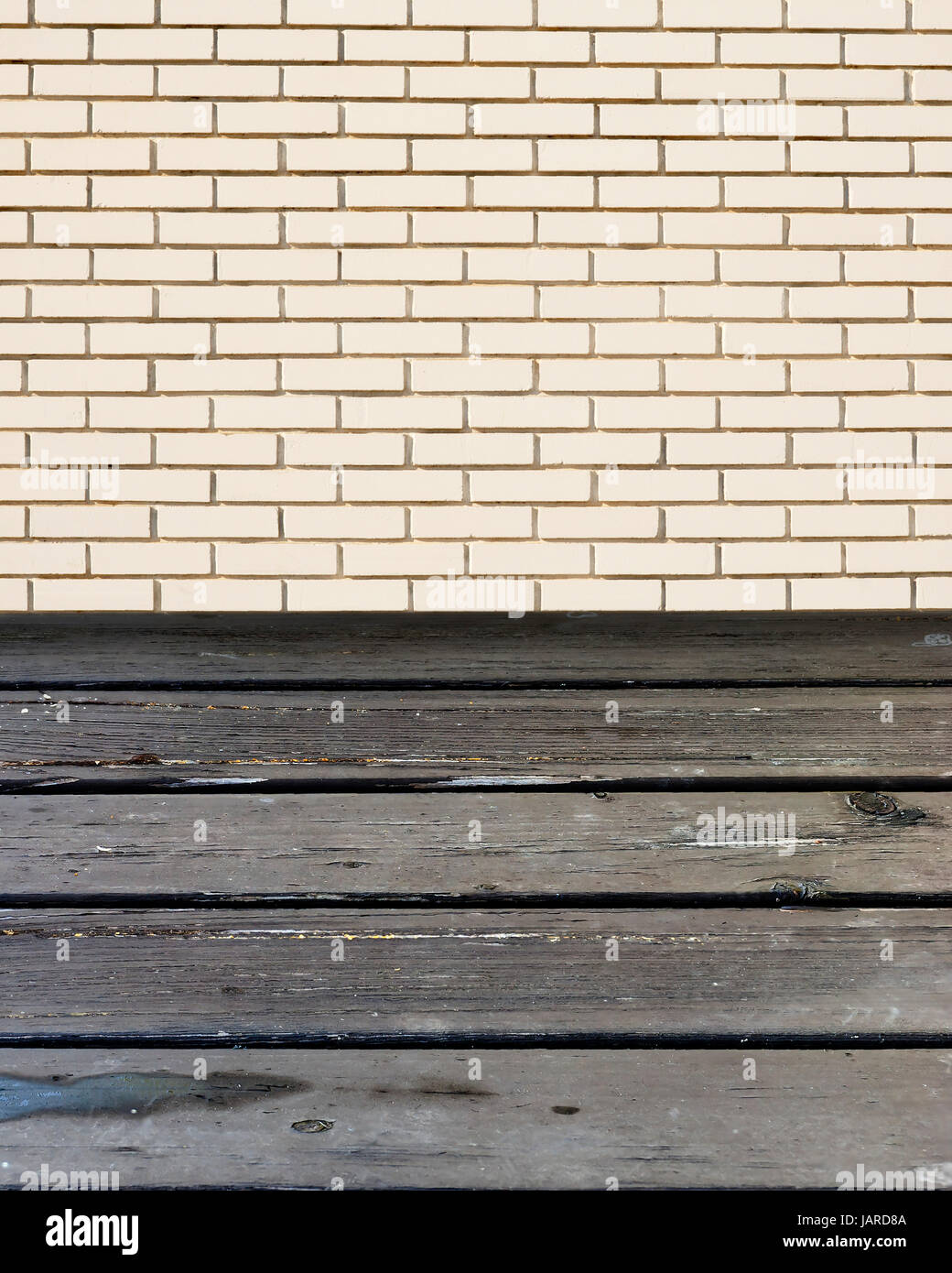Wooden table with white brick wall Stock Photo - Alamy