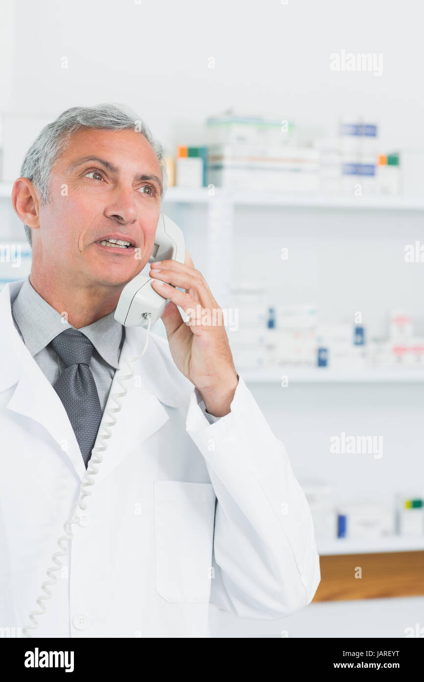 Pharmacist standing in a pharmacy while telephoning in a hospital Stock ...